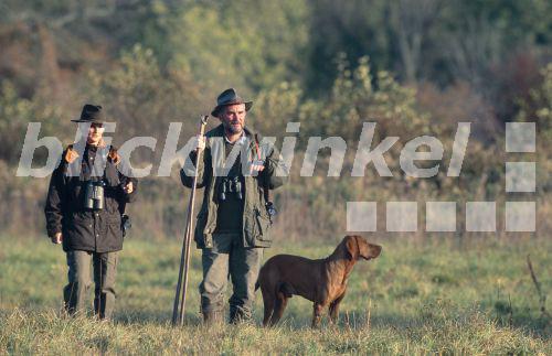 blickwinkel - zwei Jaeger mit Jagdhund, Deutschland - two hunters with ...