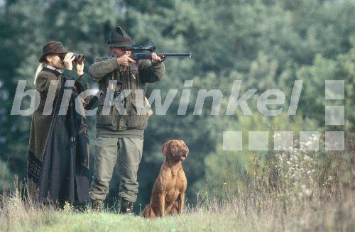 blickwinkel - zwei Jaeger mit Jagdhund, zielt mit Gewehr. - two hunters ...