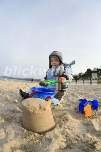 blickwinkel - kleiner Junge spielt im Winter am Sandstrand, Deutschland ...