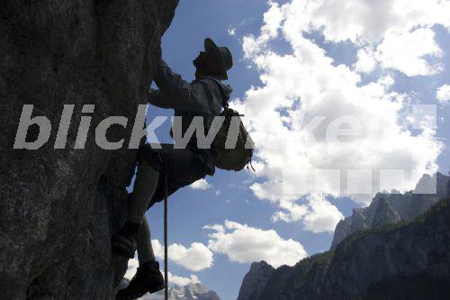 blickwinkel - historischer Bergsteiger beim Felsklettern im Gegenlicht ...