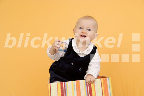 blickwinkel - Baby mit Rassel steht in einer Kiste - baby with rattle ...