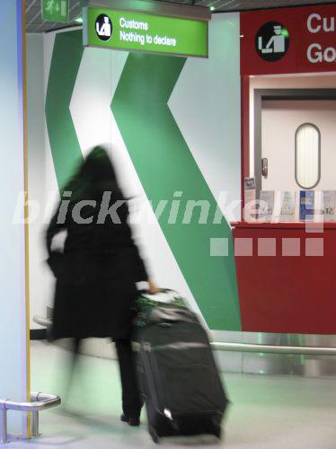 blickwinkel - Reisende passiert ein Leuchtschild im Flughafen mit dem ...