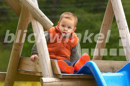 blickwinkel - Kleiner Junge sitzt auf einer Rutsche - Young boy is ...